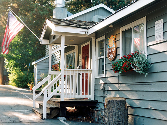 The quintessential Tahoe hideaway &ndash; a blue cabin nestled among pines, complete with white porch and American flag. Breakfast paradise awaits!