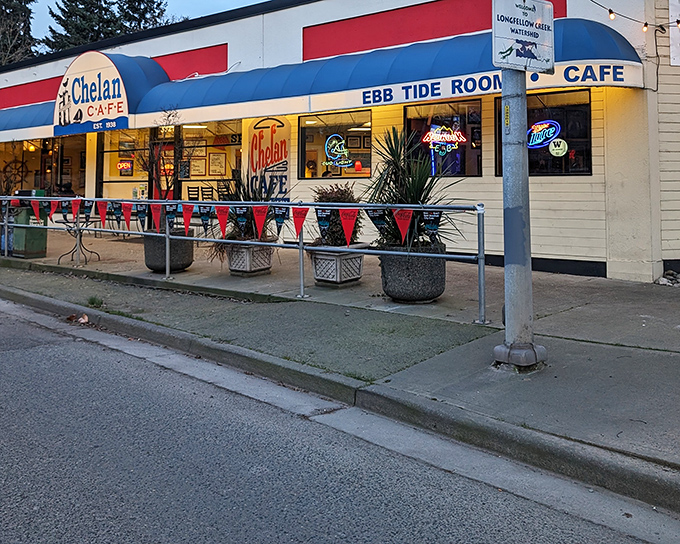 The classic red, white, and blue exterior of Chelan Cafe beckons like a lighthouse for hungry sailors. The "Ebb Tide Room" sign hints at maritime connections that run deep in West Seattle.