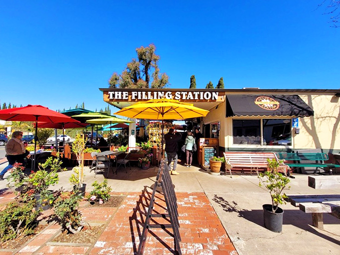 The sunny facade of The Filling Station beckons like an oasis of breakfast bliss, complete with cheerful yellow umbrellas and an inviting patio.