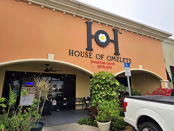 That coral-colored exterior promises serious breakfast business &ndash; and those tropical plants whisper "Florida magic awaits."