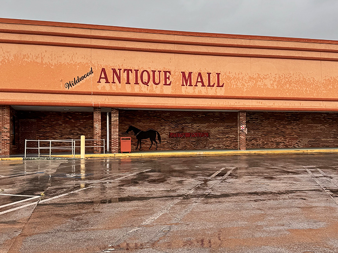 The coral-colored exterior of Wildwood Antique Mall stands as a beacon for treasure hunters, complete with its nostalgic horse and carriage silhouette.