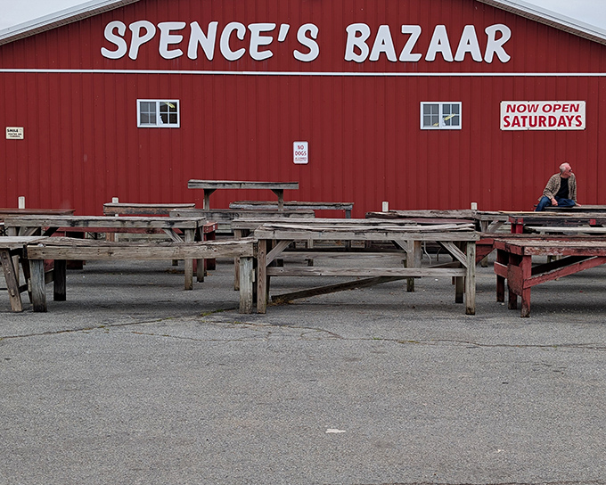 The iconic red barn of Spence's Bazaar stands ready for treasure hunters, with wooden tables awaiting vendors and their wares.