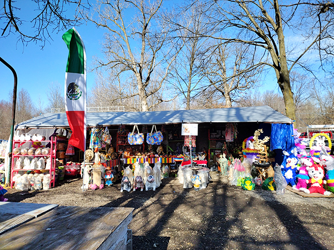 A colorful vendor stall bursting with plush toys, handcrafted bags, and festive decorations. The Mexican flag adds a vibrant splash of cultural flair.