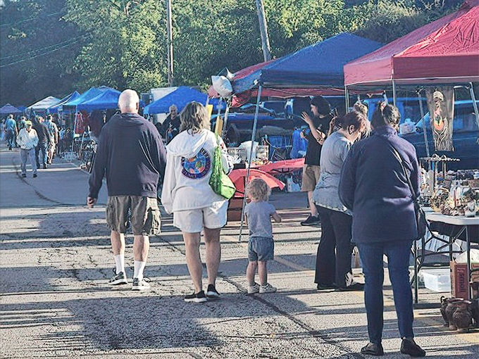 The outdoor vendor area buzzes with weekend treasure hunters. Three generations browse together, proving flea market adventures are best shared as family affairs.