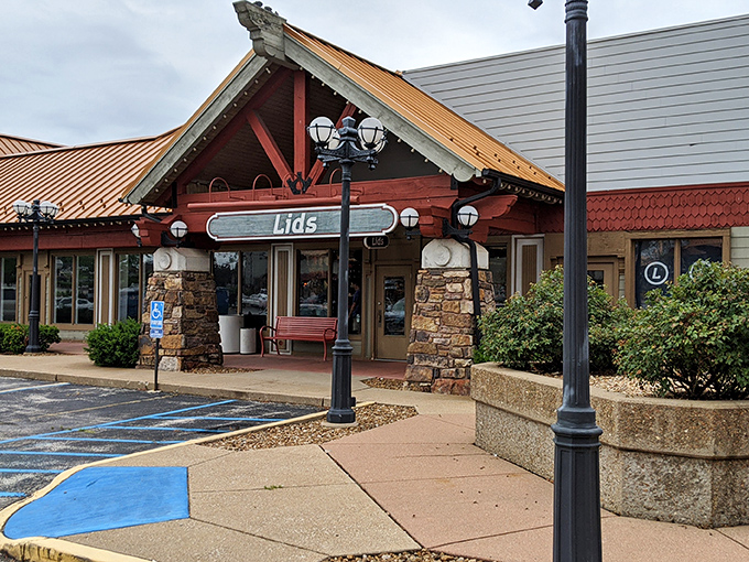 Lids store entrance showcases the marketplace's rustic-meets-retail architecture, where stone pillars and wooden beams frame discount treasures within.