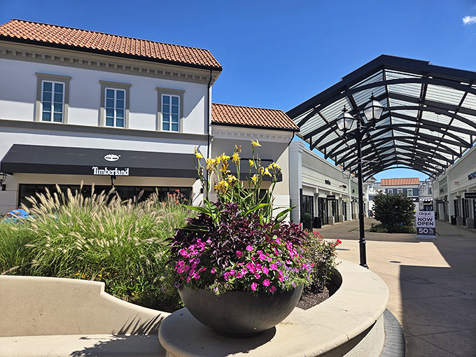 Mediterranean-inspired architecture meets modern retail therapy, with terra cotta roofing and carefully curated planters that elevate the humble outlet mall to destination status.