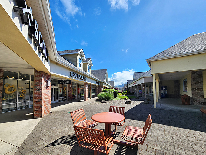 The coastal sunshine illuminates Coach and neighboring storefronts, while a welcoming seating area invites shoppers to pause and contemplate their next retail conquest.