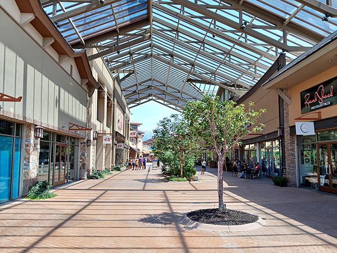 Sunlight streams through the glass ceiling, creating a shopping experience that feels more like a stroll through an upscale village than a bargain hunt.
