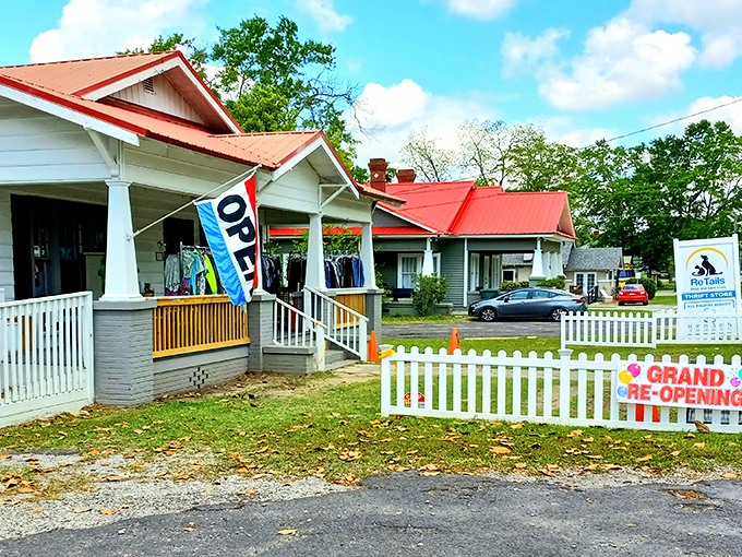 The charming cottage-style exterior of ReTails Thrift Shop beckons with its bright red roof and white picket fence—a treasure hunt disguised as a building.