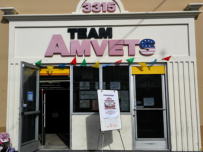 The welcoming entrance to AMVETS, where colorful pennant flags promise a treasure hunt inside that's more exciting than finding extra fries at the bottom of your takeout bag.