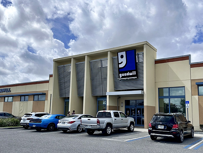 The modern exterior of Goodwill Goldenrod stands like a beacon of bargain hope under Florida's endless blue sky.