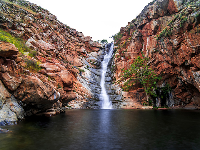Nature's perfect curtain call: Cedar Creek Falls cascades 80 feet down polished granite walls into an emerald pool that looks Photoshopped but is gloriously real.