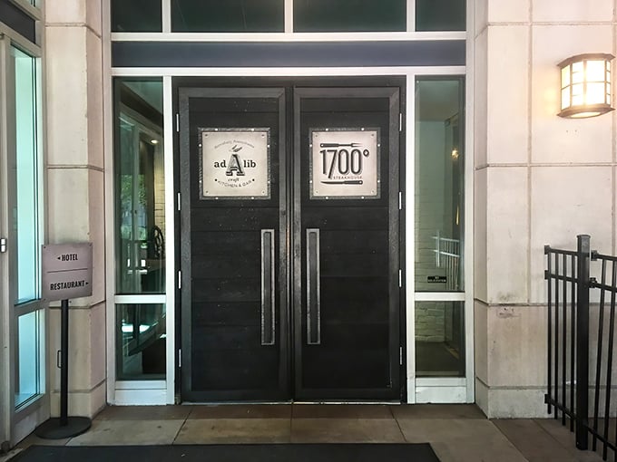 The sleek black doors of 1700 Degrees Steakhouse stand like gatekeepers to a carnivore's paradise, promising delicious secrets within.