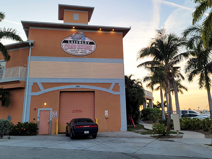 The peachy-orange exterior of Laishley Crab House stands like a beacon for hungry seafood lovers, promising Florida flavors with a side of harbor views.
