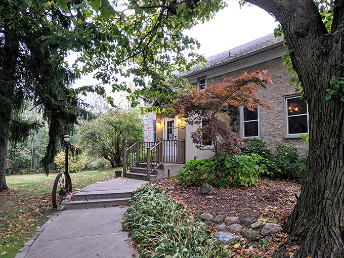 The historic stone exterior of The Farmstead welcomes you with rustic charm, complete with a wagon wheel entrance that whispers, "Slow down, good food takes time."