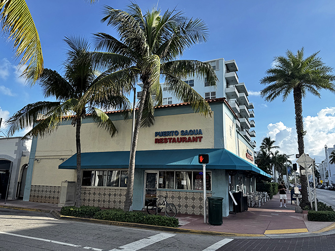 The palm-flanked blue and white exterior of Puerto Sagua stands like a culinary lighthouse amid South Beach's glitz, promising authentic Cuban flavors inside.
