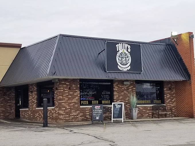 Tolly's neon sign stands like a culinary beacon in the gloom, drawing hungry travelers with promises of pizza, beer, and wings.