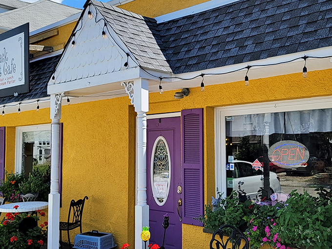 The purple door beckons like a royal invitation to this sunshine-yellow cafe, where string lights promise magic even in daylight hours.