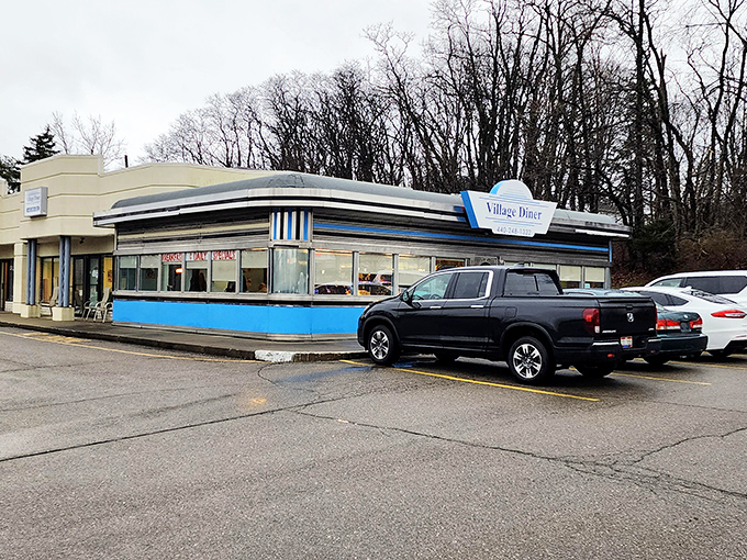 The classic blue-and-white exterior of Village Diner stands like a time capsule of Americana, beckoning hungry travelers with promises of comfort food perfection.