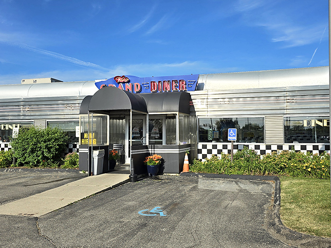The gleaming stainless steel exterior of The Grand Diner stands like a time machine in Novi, promising nostalgic flavors with that unmistakable neon glow.
