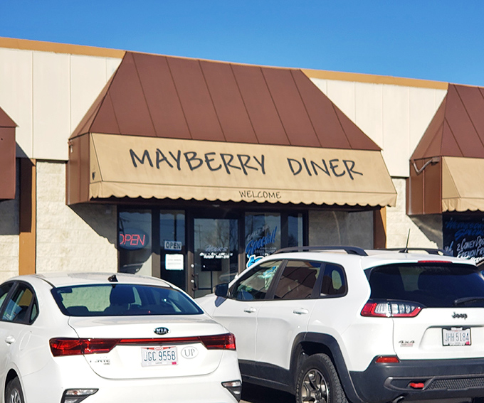 Morning sunshine bathes Mayberry's welcoming facade, where cars already gather like breakfast enthusiasts plotting their waffle strategy.