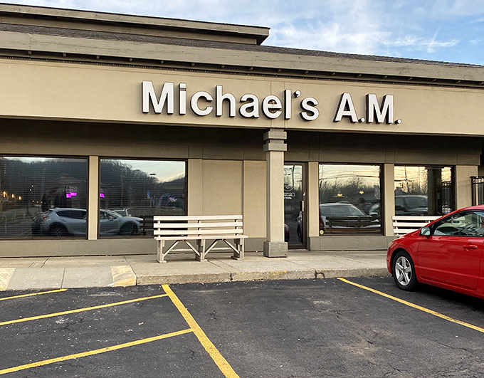 Morning light bathes the entrance where a simple white bench invites you to pause before the breakfast adventure begins. The best journeys often start with a moment of anticipation.
