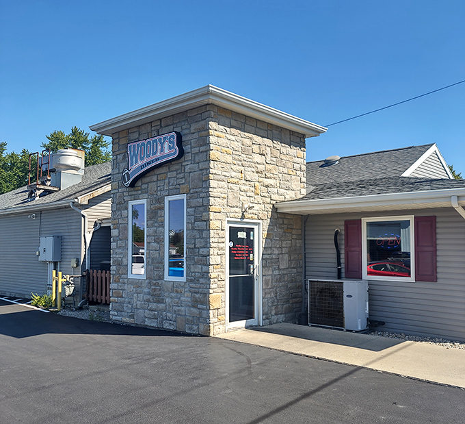 The stone-front entrance of Woody&rsquo;s welcomes diners with a sturdy charm, inviting all to discover hearty comfort food inside.