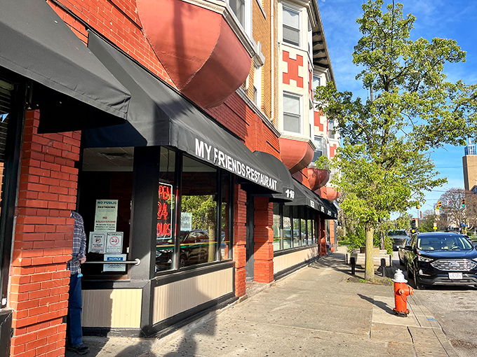 The distinctive orange-brick fa&ccedil;ade of My Friend's Restaurant stands as a Cleveland landmark, promising comfort beneath those classic red awnings.