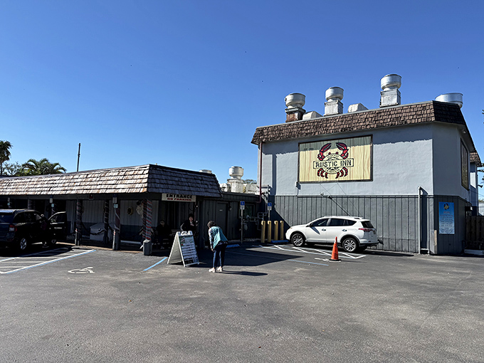 The blue clapboard exterior of Rustic Inn Crabhouse beckons like a siren song to seafood lovers, promising waterfront dining and legendary garlic crabs.
