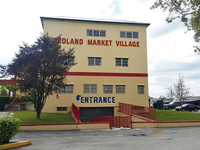 The cream-colored facade of Redland Market Village stands like a bargain hunter's lighthouse, beckoning shoppers with its distinctive red trim and promise of treasures within.
