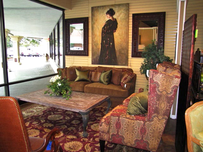 Elegant vignette showcases The Missing Piece's artful curation—where vintage artwork meets luxurious seating in a perfectly styled living room tableau.