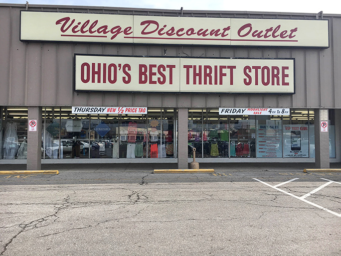 The bold red lettering of Village Discount Outlet beckons bargain hunters like a retail lighthouse in a sea of overpriced shopping options.