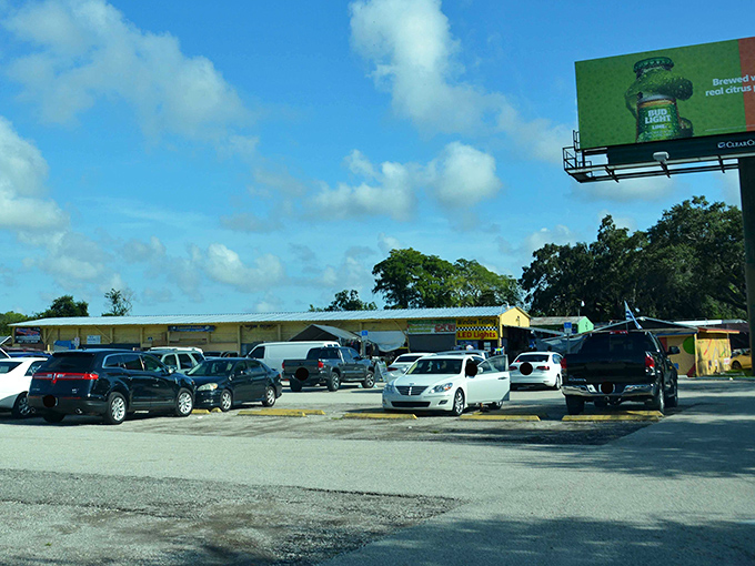 Rows of cars pack the lot outside OBT Flea Market, hinting at aisles of bargains and hidden gems inside.