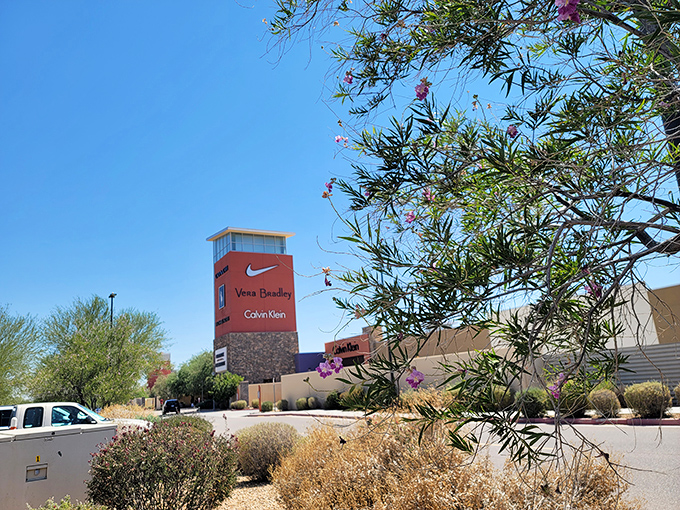 The iconic tower stands like a retail lighthouse, beckoning bargain hunters with promises of Nike, Vera Bradley, and Calvin Klein treasures waiting to be discovered.