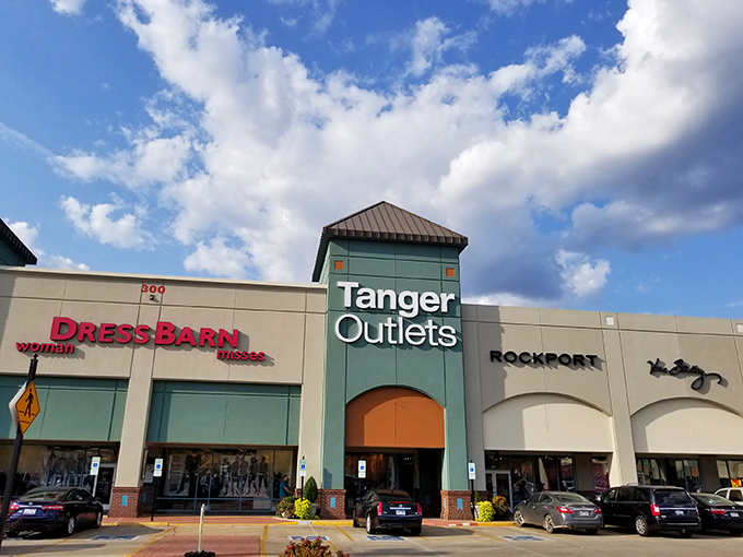 The retail promised land beckons with its iconic green tower. Tanger Outlets stands ready to transform your wallet's contents into shopping bags of joy.