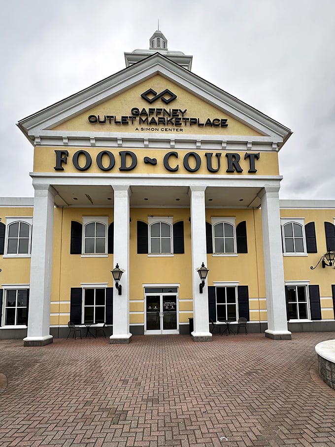 The grand colonial-style entrance to Gaffney Outlet Marketplace's food court stands like a temple to retail therapy, promising sustenance for weary bargain hunters.