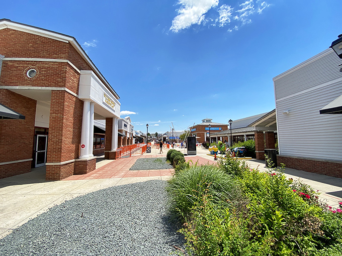 Sunshine bathes the brick facades and welcoming storefronts. This isn't your typical strip mall&mdash;it's where Virginia charm meets designer discounts.