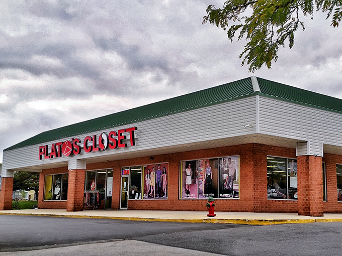 The bright red signage of Plato's Closet beckons like a fashion lighthouse, promising treasure within those brick walls.