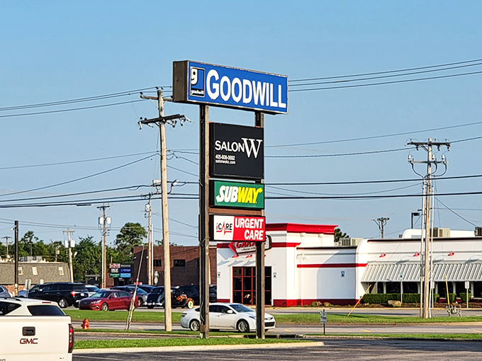The iconic blue Goodwill sign stands tall among neighboring businesses, like a beacon calling all treasure hunters to their retail paradise.