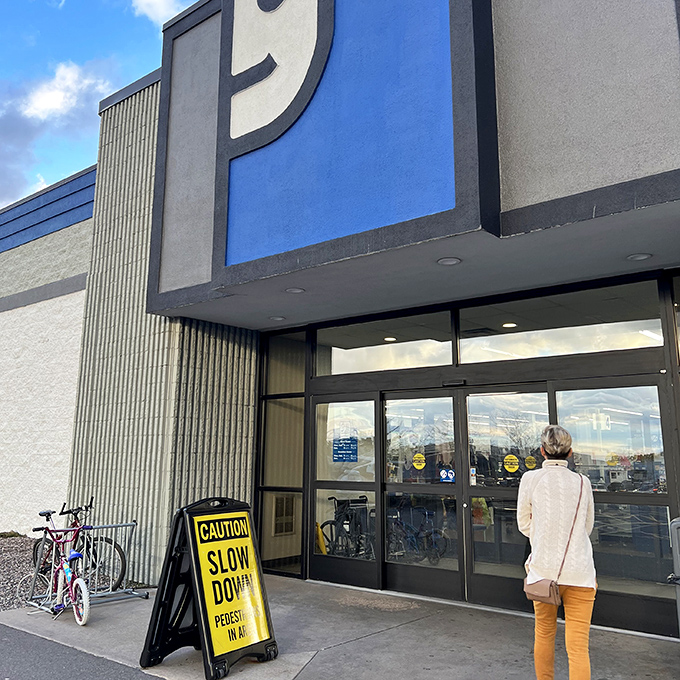 A single customer pauses in front of the iconic smiling &lsquo;g&rsquo; logo, ready to step into this thrift paradise where yesterday&rsquo;s discards are given a second chance at greatness.