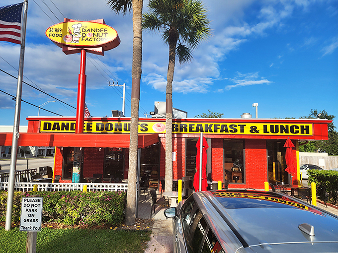 The iconic red and yellow exterior of Dandee Donut Factory stands like a beacon of breakfast hope on Federal Highway. Palm trees included, no extra charge.