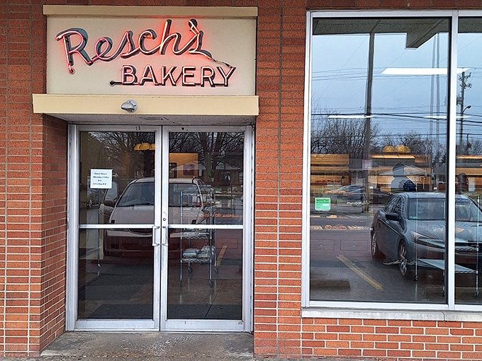 The glowing red neon sign of Resch's Bakery beckons like a lighthouse for the sugar-deprived, promising sweet salvation behind those unassuming brick walls.