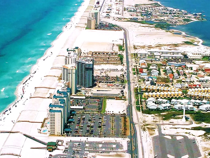 Aerial paradise: Navarre's pristine coastline stretches like nature's welcome mat, where turquoise waters meet sugar-white sands in a perfect Florida embrace.