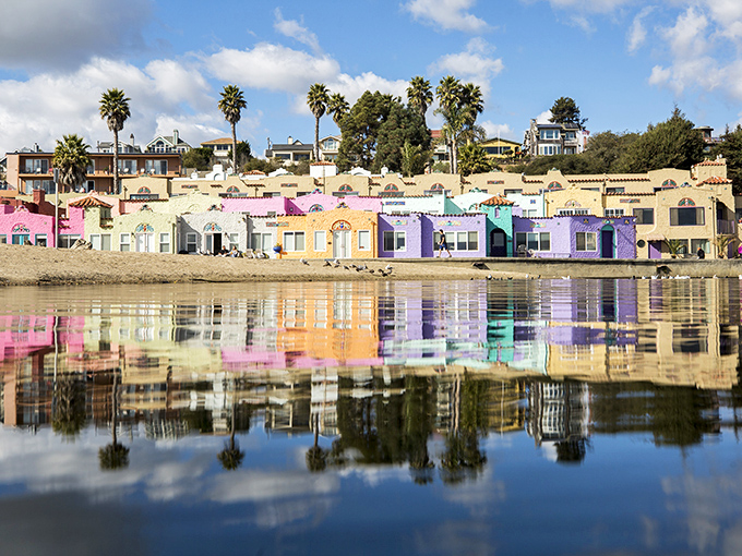 The famous candy-colored Venetian Court reflects perfectly in Soquel Creek, creating a double rainbow of architectural delight that defines Capitola's unique charm.