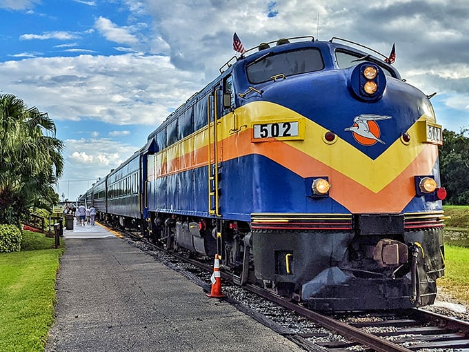 The iconic blue and yellow Seminole Gulf Railway locomotive cuts a striking figure against Florida's sky, like a time-traveling chariot ready for adventure.