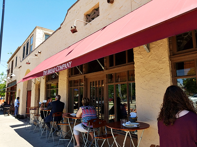 The iconic yellow facade and red awning of The Bread Company stands like a beacon of culinary hope on Urbana's Goodwin Avenue.