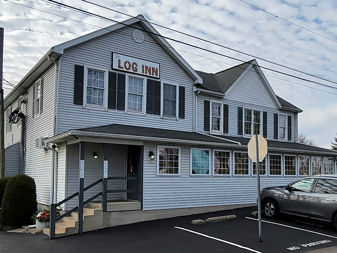 The unassuming white exterior of The Log Inn hides culinary treasures within, like finding a five-star restaurant disguised as your grandparents' house.
