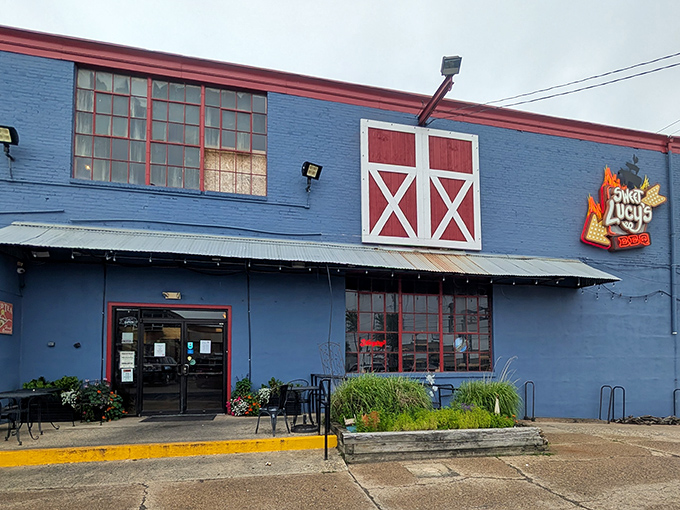 The blue building with red barn doors isn't trying to impress anyone—until you taste what's smoking inside. Sweet Lucy's exterior promises authentic barbecue without the frills.