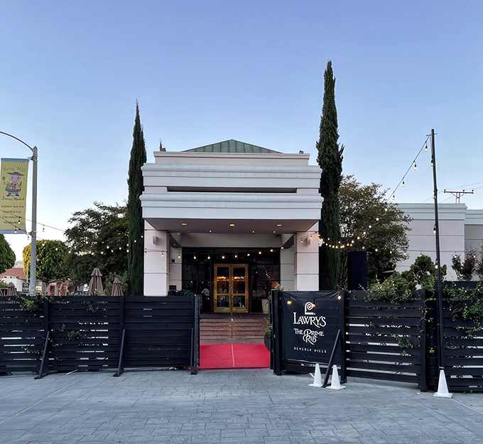 The grand entrance to Lawry's beckons with its elegant white fa&ccedil;ade and stately cypress trees. That red carpet isn't just for show&mdash;it's your first clue this isn't an ordinary dinner.