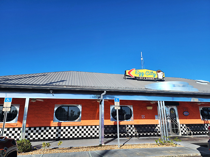 The bright orange exterior of Egg City Diner stands out like a beacon for breakfast lovers, complete with retro checkered trim and porthole windows.